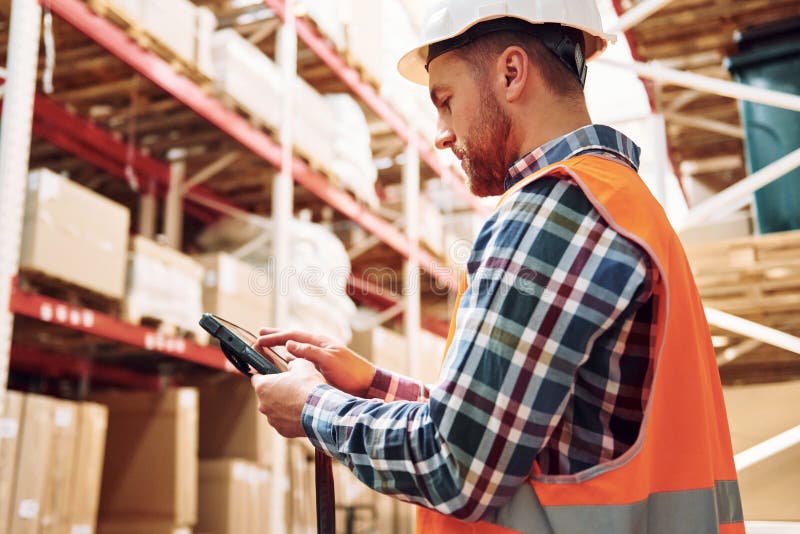 Holding Tablet in Hands. Employee in Uniform is Working in the Storage ...