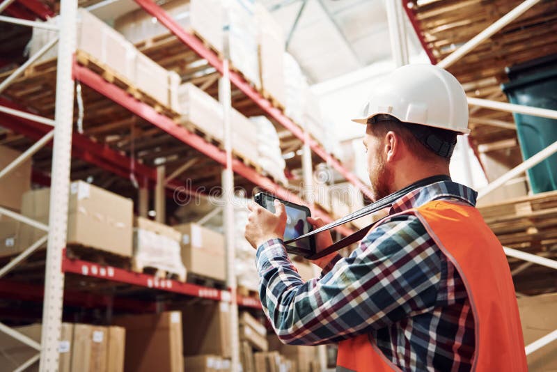 Holding Tablet in Hands. Employee in Uniform is Working in the Storage ...
