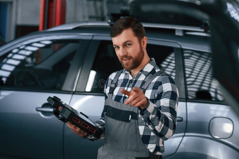 Holding Tablet. Man in Uniform is Working in the Auto Salon Stock Image ...