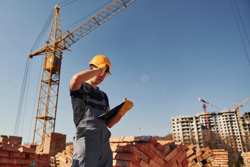 Holds Notepad with Documents. Construction Worker in Uniform and Safety ...
