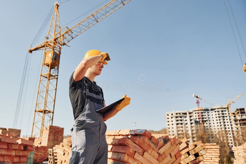 Holds Notepad with Documents. Construction Worker in Uniform and Safety ...