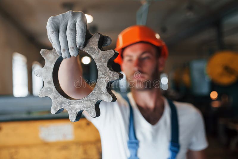 Holds in One Hand. Man in Uniform Works on the Production Stock Image ...