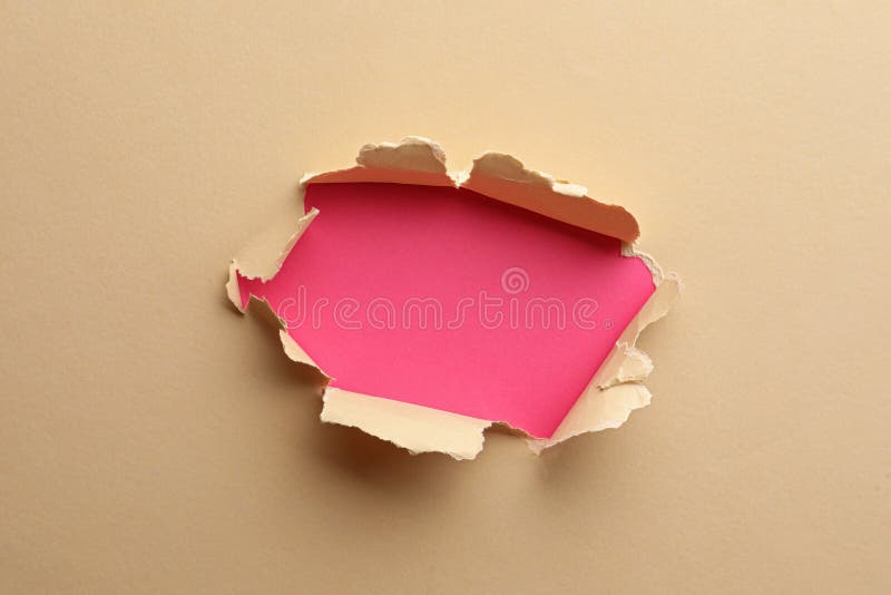 Hole in Light Beige Paper on Pink Background Stock Photo - Image of ...