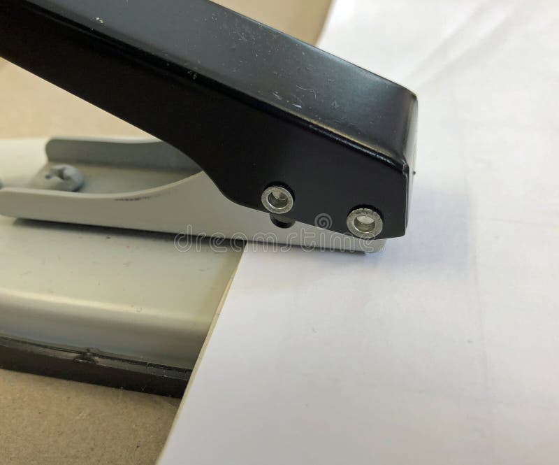 A Hole Punch Putting a Hole in a Piece of Paper. Stock Image - Image of ...