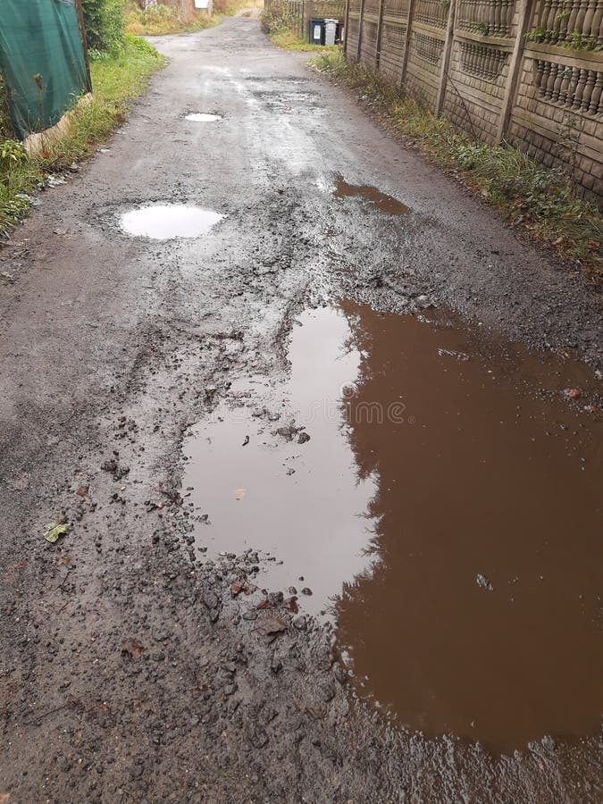 Holey non-asphalt road stock image. Image of waterway - 296578687