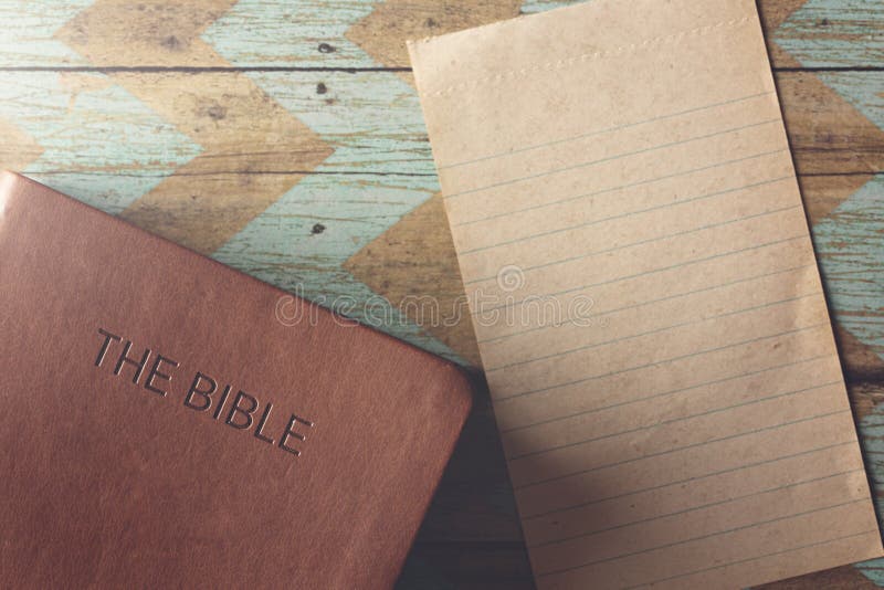 Holy Bible on a Rustic Wooden Table with a Blank Piece of Antique Paper ...