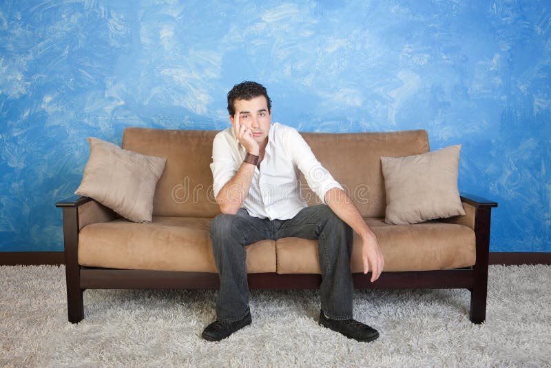 Hombre aburrido en el sofá imagen de archivo. Imagen de blanco - 21218005
