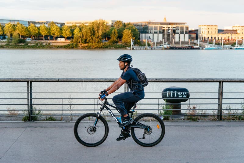 Hombre Joven Que Monta Una Bicicleta Por La Orilla En Burdeos Foto de ... Hombre Joven Que Monta Una Bicicleta Por La Orilla En Burdeos Foto de ...