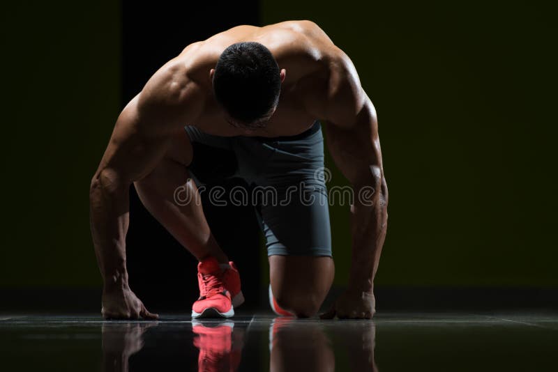 Hombres Musculares Fuertes Que Se Arrodillan En El Piso Imagen De