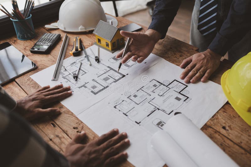 The Home Design Architects are Reviewing the House Plan Draft, the Project Commissioned by the ...