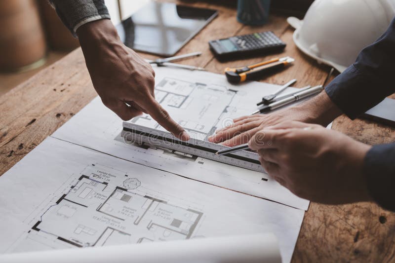 The Home Design Architects are Reviewing the House Plan Draft, the Project Commissioned by the ...