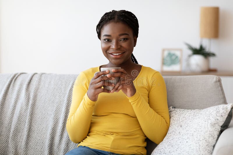 Home Leisure Smiling African Woman Drinking Coffee While Relaxing In