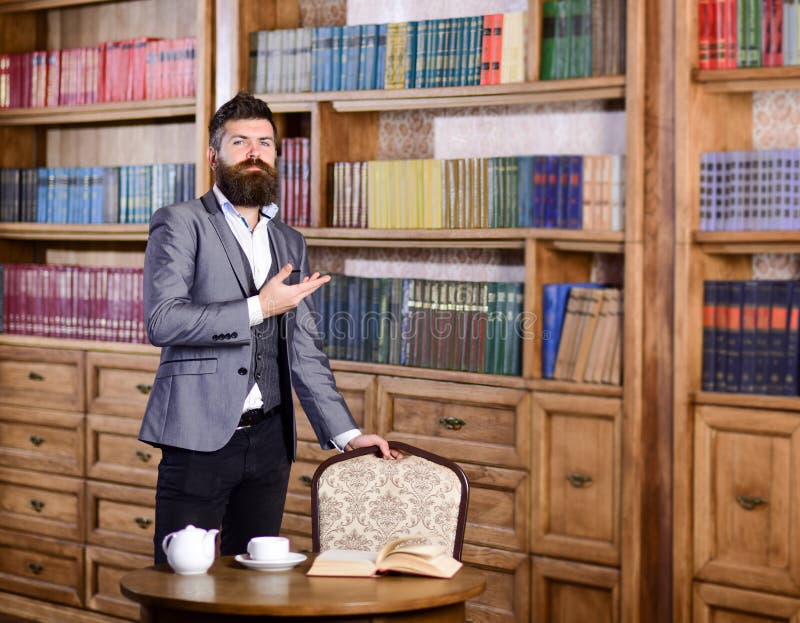 Home Library Concept. Mature Man in Formal Suit Shows Home Library ...