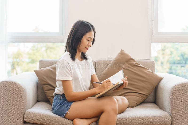 Home Relaxation Concept, Young Woman Sitting on Couch To Taking Notes ...