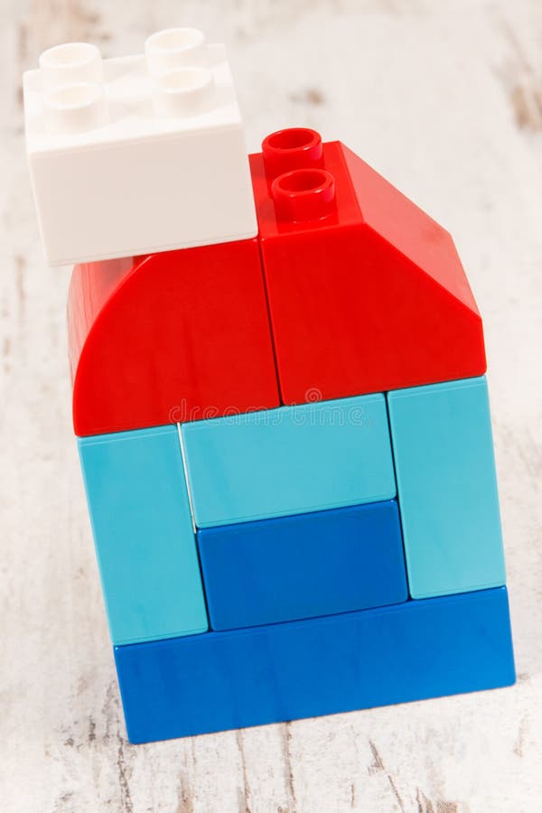 Home Shape Made of Plastic Toy Blocks on Rustic Board. Building or ...