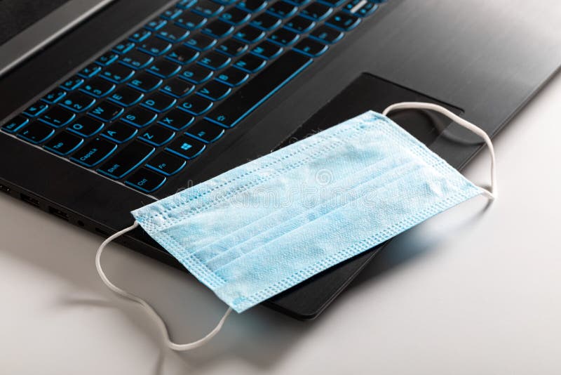 Home Work during Covid 19 Pandemic. Computer and Blue Mask Stock Photo ...