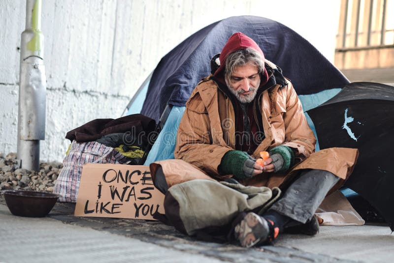 Homeless Beggar Man Sitting Outdoors In City Asking For Money Donation
