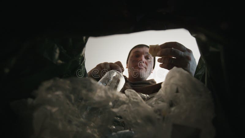 The Homeless Man Digs in the Trash. Bottom View from the Trash Bin ...
