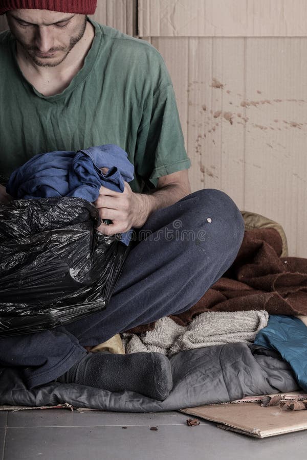 Homeless Man Looks a Bag of Clothes Stock Photo - Image of clothes ...