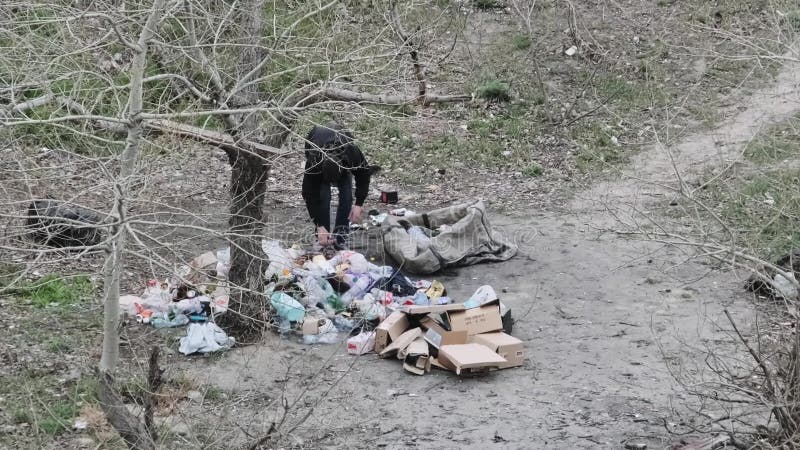 Homeless Man Rummages the Garbage and Sorting Plastic Bottles Stock ...