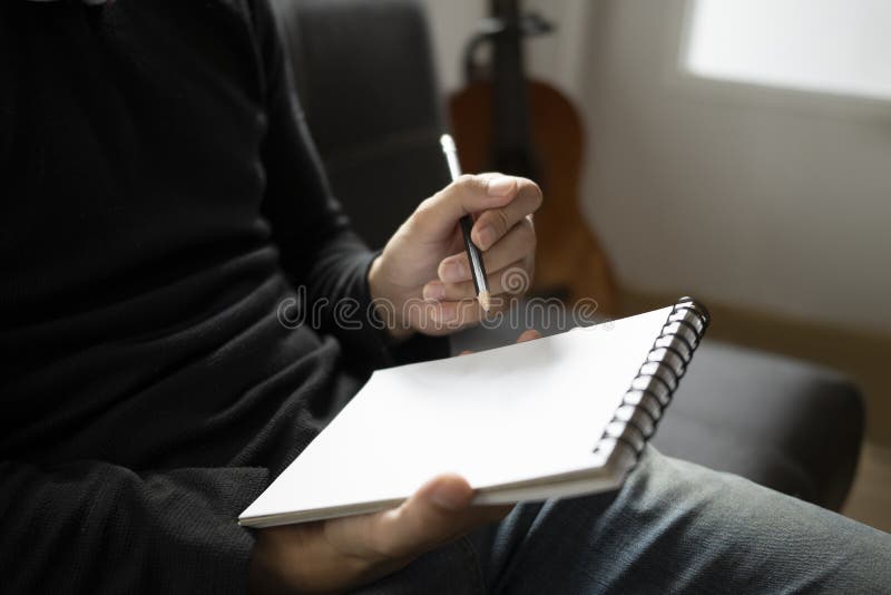 Homem Anotando No Notebook Sentado No Sofá. Foto de Stock - Imagem de ...