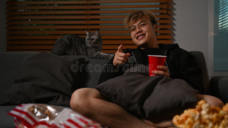 Homem Feliz Com Controle Remoto Comendo Pipoca E Assistindo Filme Na ... Homem Feliz Com Controle Remoto Comendo Pipoca E Assistindo Filme Na ...