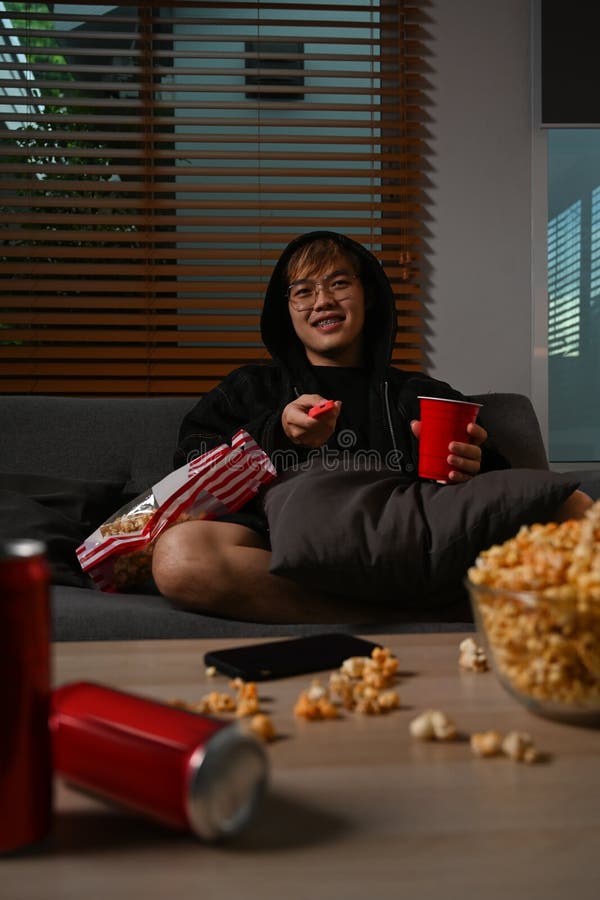 Homem Feliz Com Controle Remoto Comendo Pipoca E Assistindo Filme Na ... Homem Feliz Com Controle Remoto Comendo Pipoca E Assistindo Filme Na ...