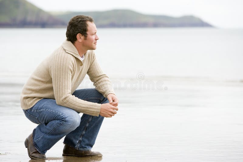 Homem Que Agacha-se Na Praia Imagem de Stock - Imagem de litoral ...