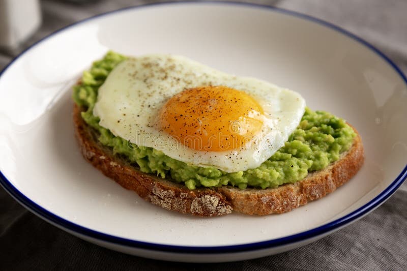 Homemade Avocado Toast with Egg on a Plate, Side View. Closeup Stock ...