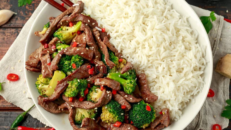 Homemade Beef and Broccoli with Rice and Herbs on Wooden Table Stock ...