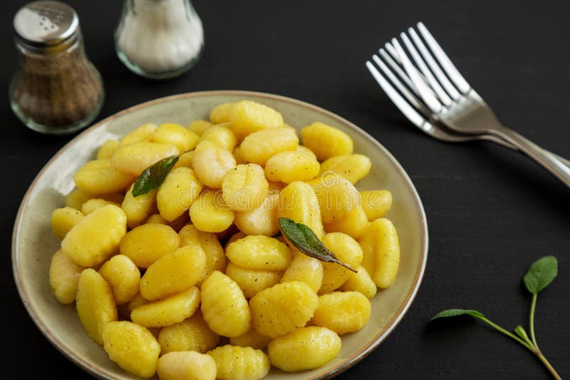 Homemade Easy Potato Gnocchi on a Plate on a Black Background, Side ...