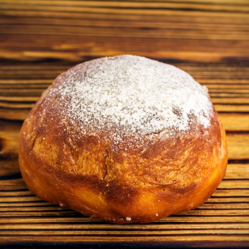 Homemade Fresh Donut Sprinkled With Powdered Sugar On Wooden Table