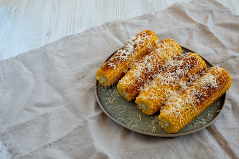 Homemade Garlic Parmesan Grilled Corn on a Plate, Side View. Space for ...