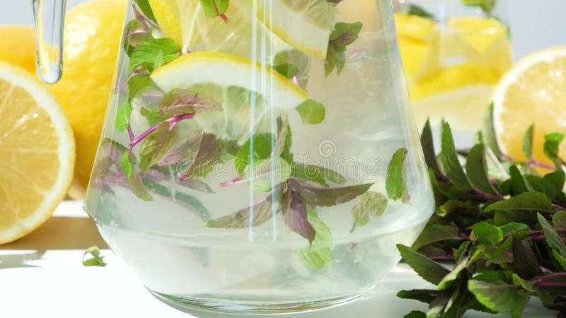 Homemade Lemonade with Lemons and Mint in a Glass Pitcher , Slow Motion ...