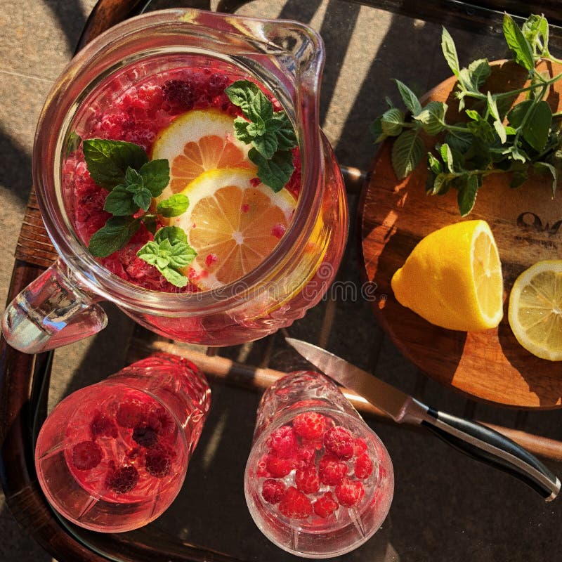 Homemade Lemonade with Raspberries, Mint, Lemon and Ice in a Decanter ...