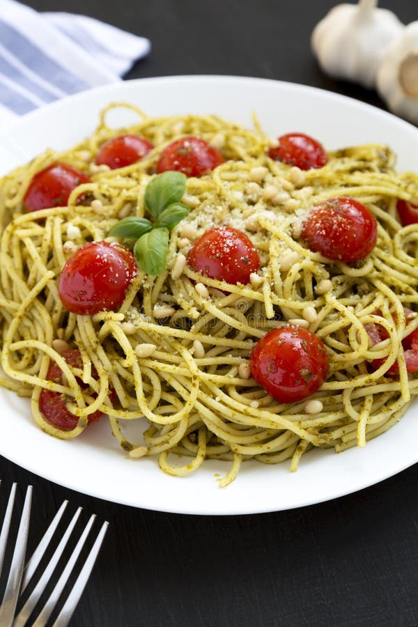 Homemade Pesto Pasta with Tomatoes and Pine Nuts on a Black Surface ...