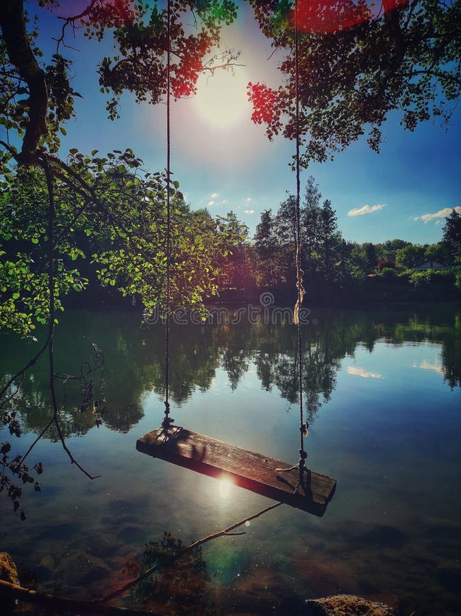 Homemade Swing Over the River. the Sun is Reflected in the Water Stock ...