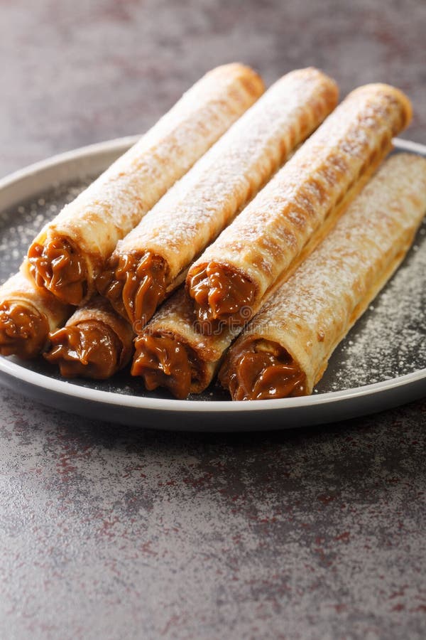 Homemade Waffles Rolls with Caramel and Powdered Sugar on the Plate ...