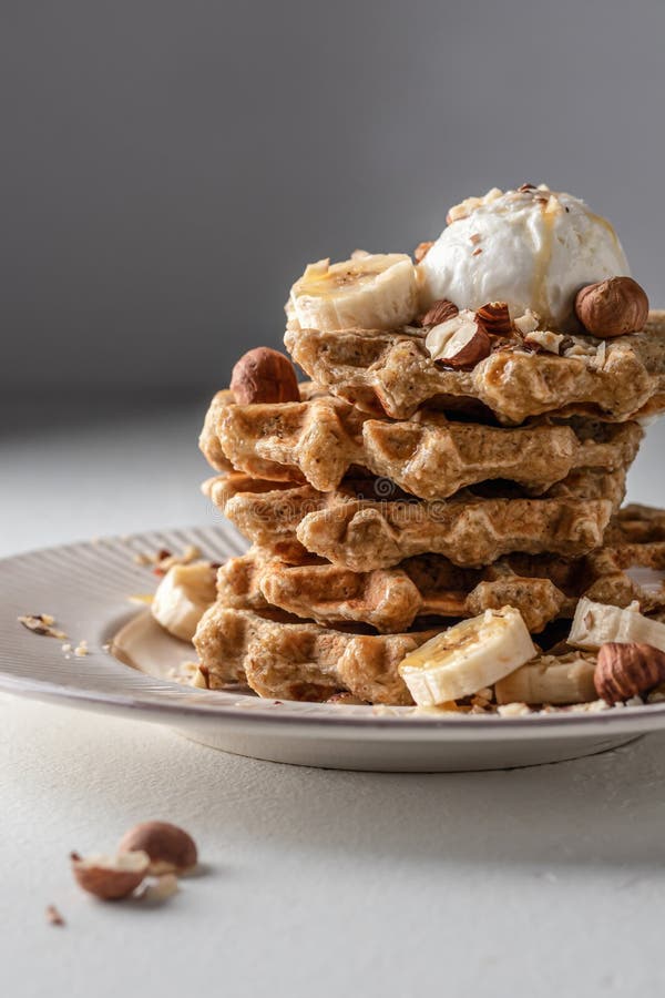 Homemade Waffles Stack with Ice Cream, Bananas and Nuts on White Plate ...