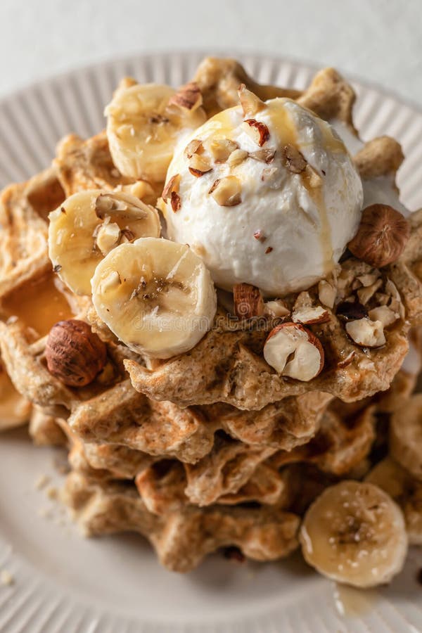 Homemade Waffles Stack with Ice Cream, Bananas and Nuts on White Plate ...