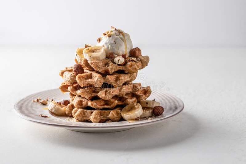 Homemade Waffles Stack with Ice Cream, Bananas and Nuts on White Plate ...