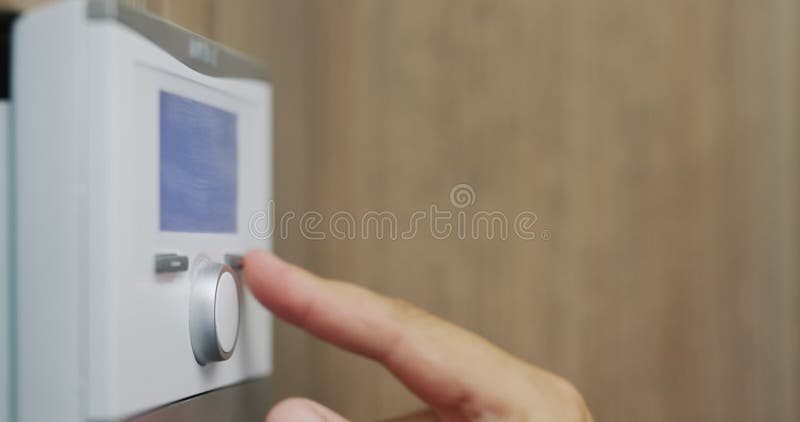 The Homeowner Regulates the Temperature in the House on the Electronic ...