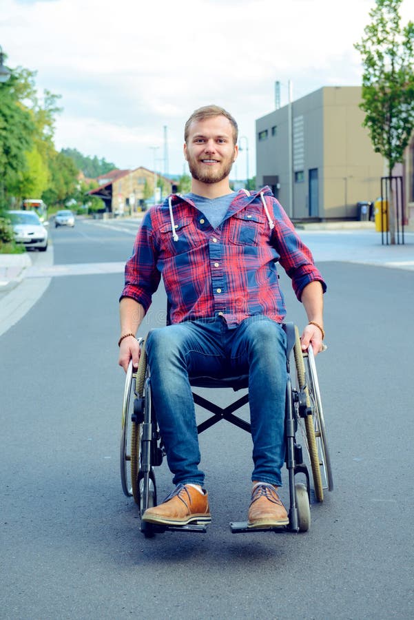 Homme Handicapé Dans Le Fauteuil Roulant Sur La Route Image Stock