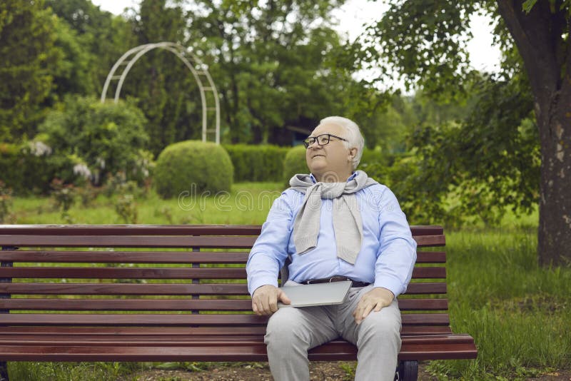 Homme âgé Heureux Avec Ordinateur Portable Assis Sur Un Banc Dans Un