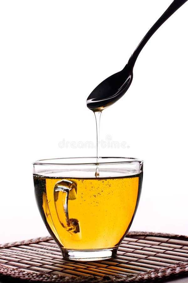 Honey Dripping from a Spoon into Tea Cup Isolated Stock Image - Image ...