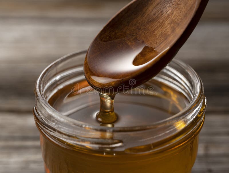 Honey and Wooden Honey Dipper in Glass Container on Old Wooden ...
