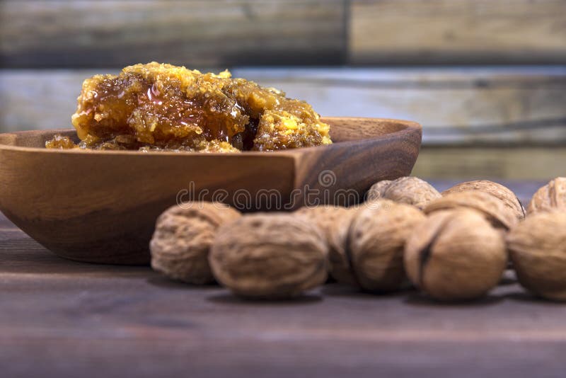 Honeycombs with Honey in a Wooden Plate and Many Inshell Walnuts on a ...