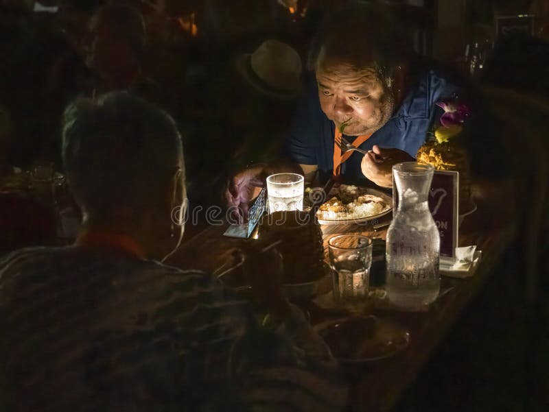 Honolulu, Hawaii, Oct 19, 2022- Shakacon - Man Eats Dinner by Light of ...
