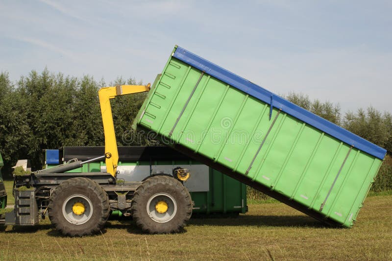 A Hook Arm is Unloading a Container in a Grass Field Closeup Editorial ...