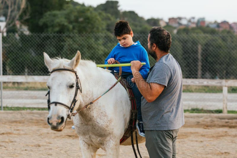Disabled Young Man Riding a Horse Assisted by an Instructor Stock Photo ...